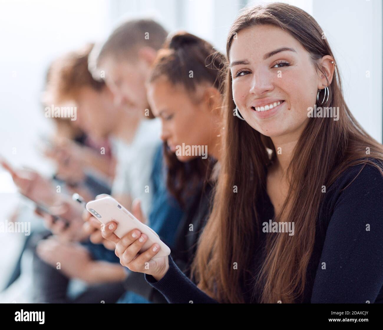 group of serious young people looking at their smartphone screens Stock ...