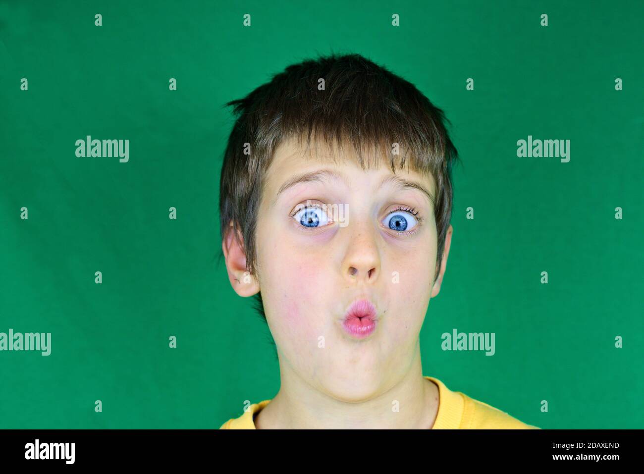 Cute Caucasian boy showing a shock on a green background Stock Photo ...