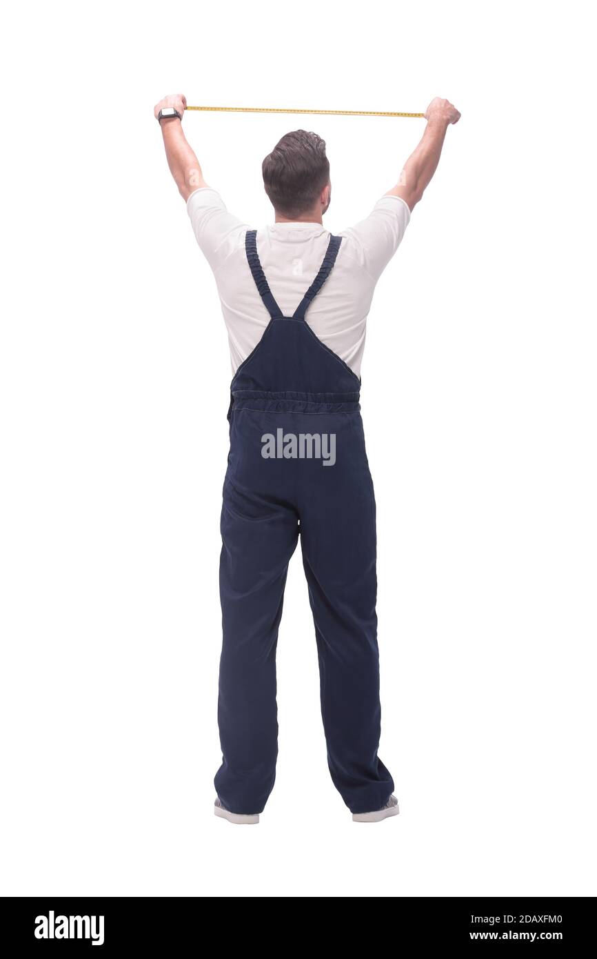 rear view. a man measuring something with a construction tape measure ...