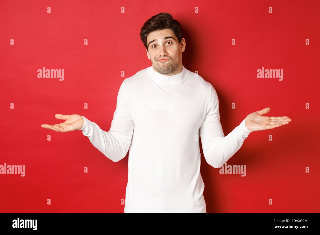 Portrait of clueless handsome guy, shrugging with hands spread sideways ...