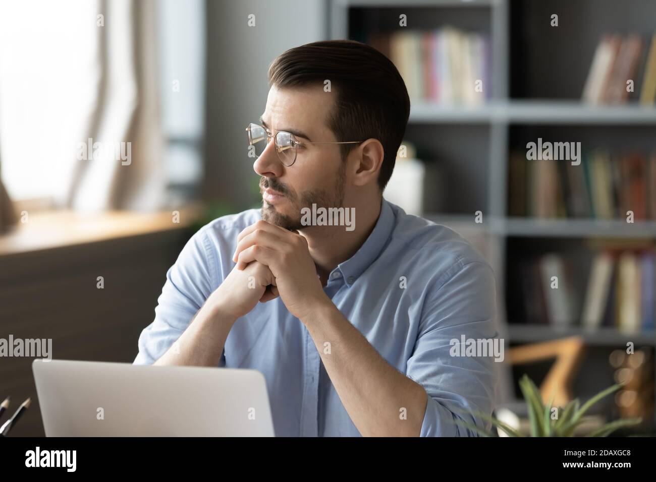 Pensive businessman distracted from computer work looking in distance ...