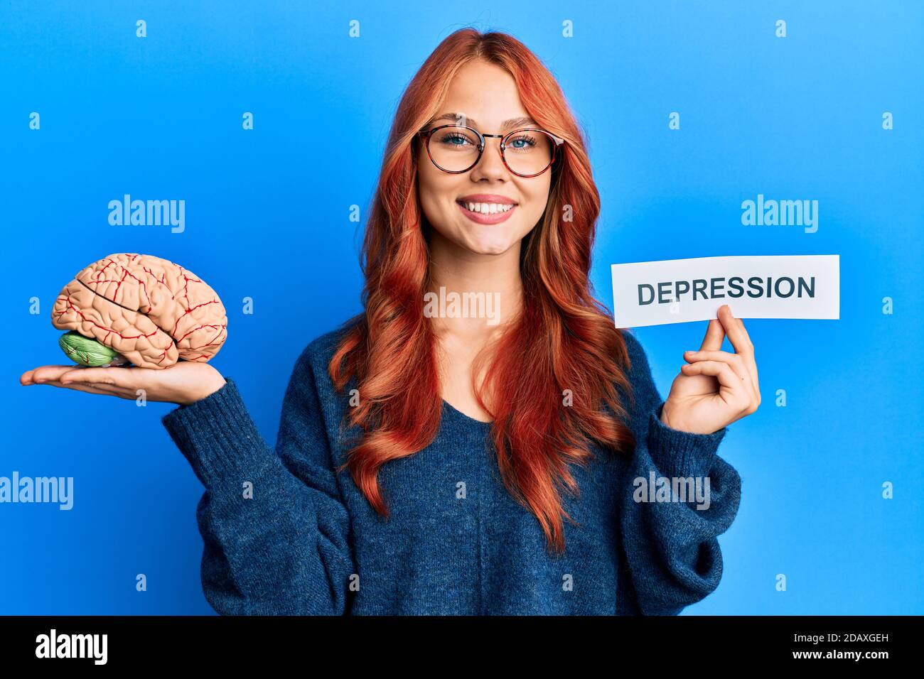 Young redhead woman holding brain and depression text smiling with a ...