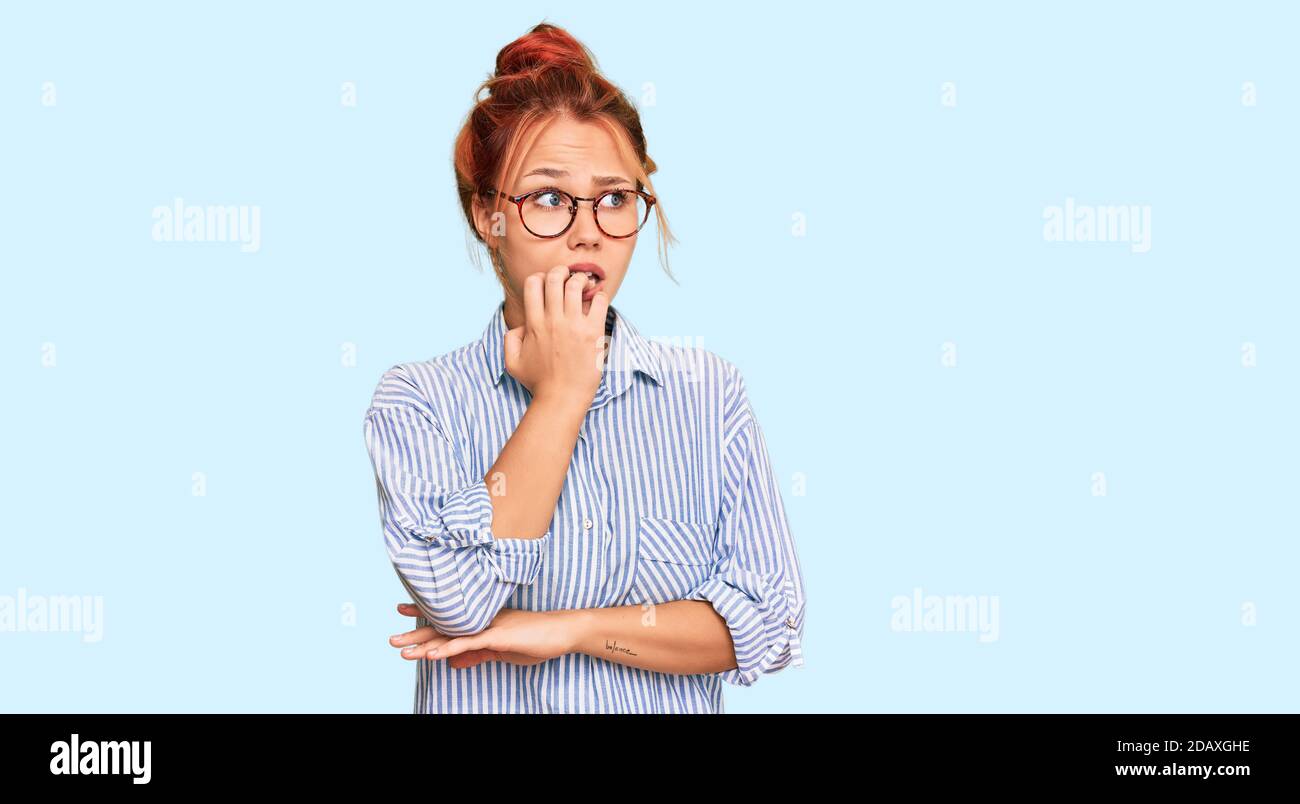 Young redhead woman wearing casual clothes and glasses looking stressed ...