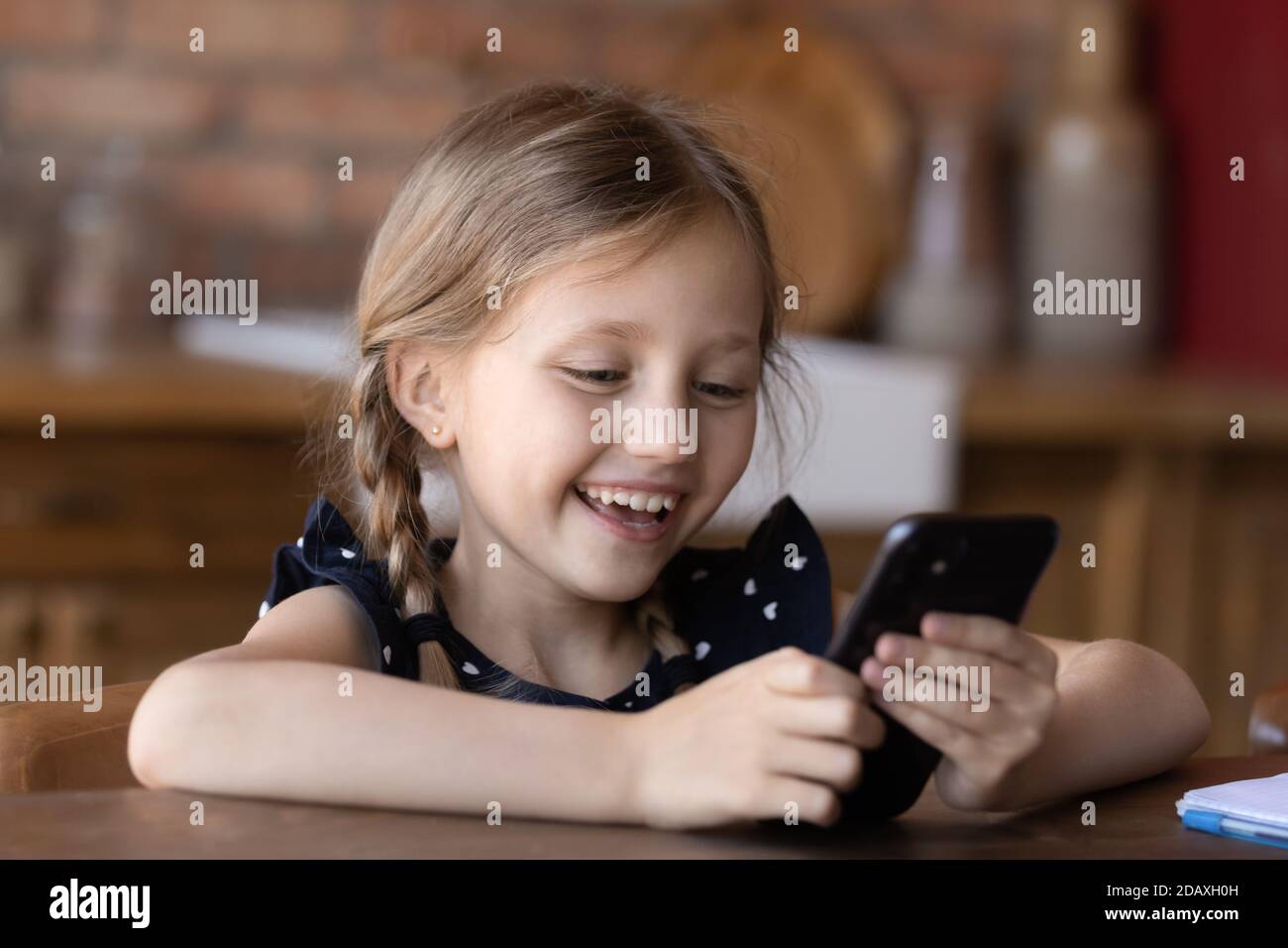 Happy little girl holding mobile phone making call to mother Stock ...