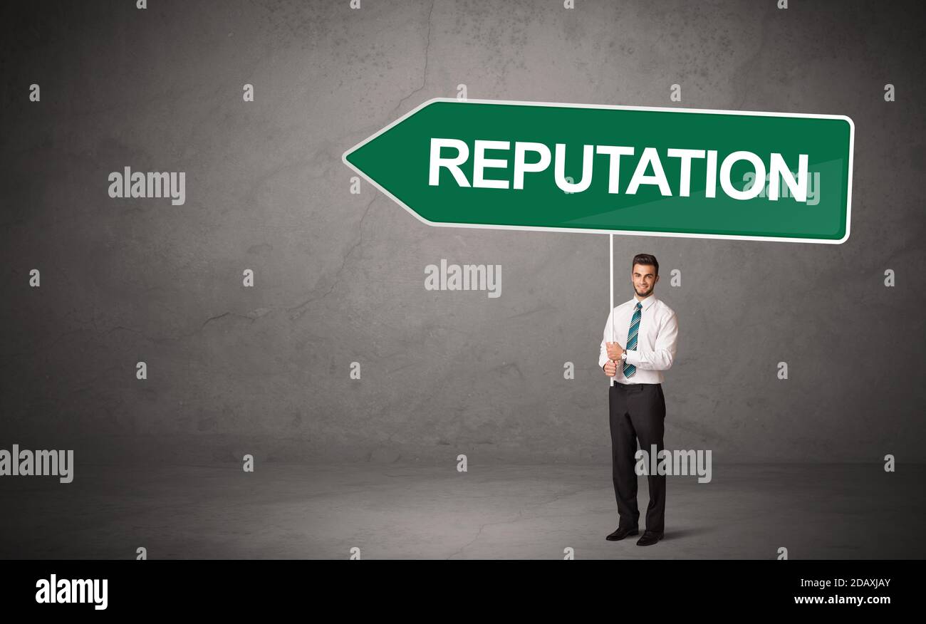 Young business person in casual holding road sign with REPUTATION ...