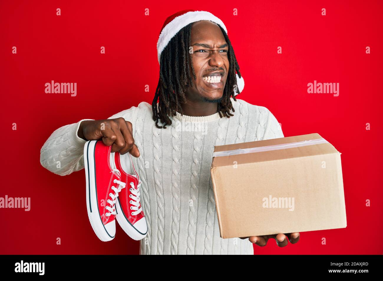 African american man with braids wearing christmas hat having shoes as ...