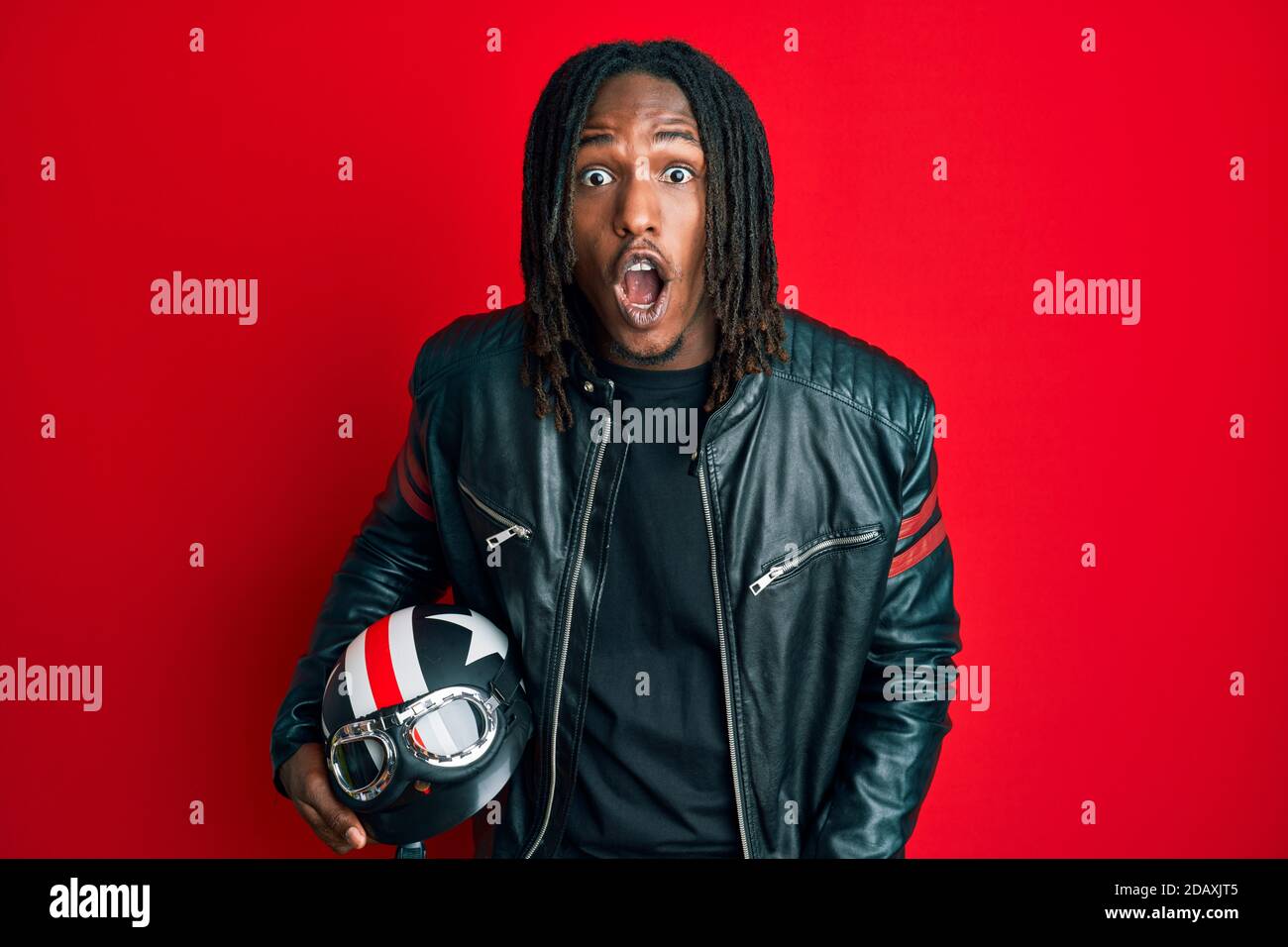African american man with braids holding motorcycle helmet scared and ...