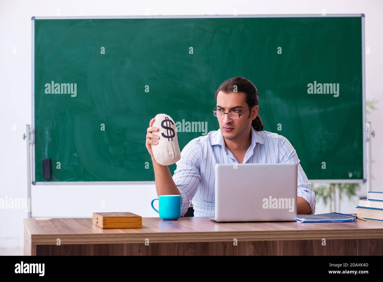 Young teacher in remuneration concept Stock Photo - Alamy