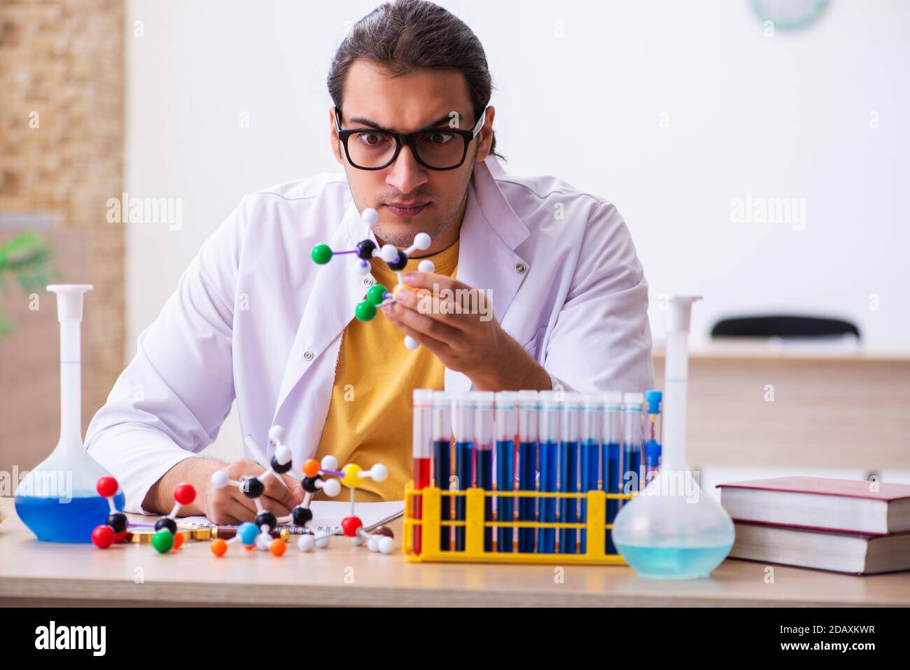 Young chemist studying molecular model in the classroom Stock Photo - Alamy