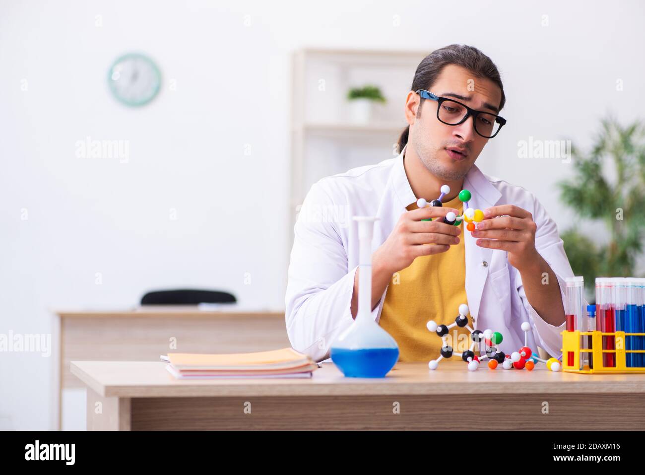 Young chemist studying molecular model in the classroom Stock Photo - Alamy