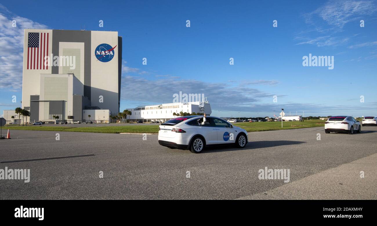 Astronauts waves from the Tesla Model X as they travel past the Vehicle ...