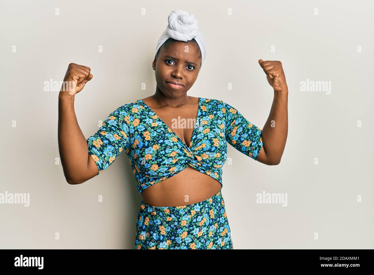 Young african woman wearing hair turban and african style showing arms ...