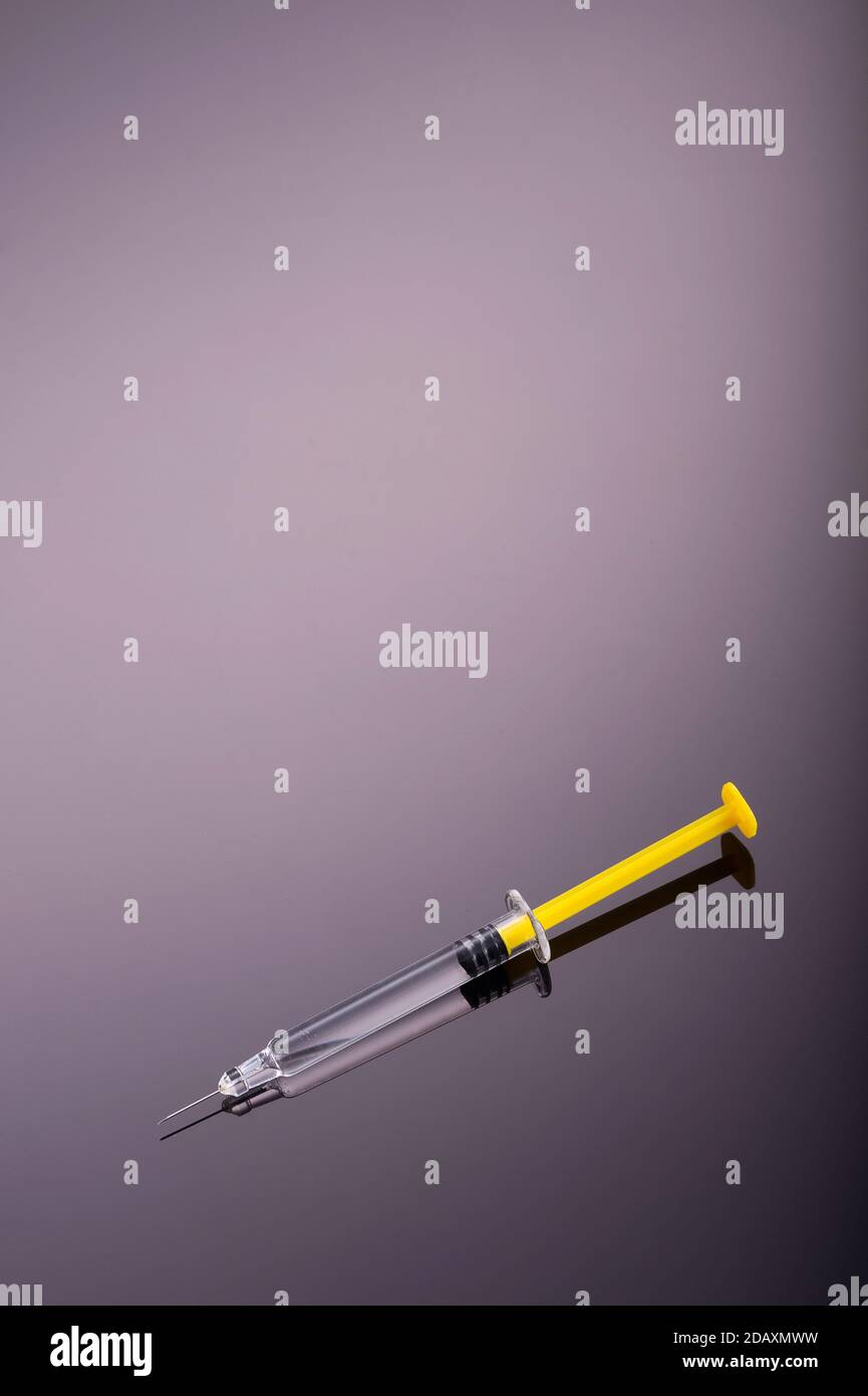 Yellow Syringe on glossy black background. Dark side of Immunization ...