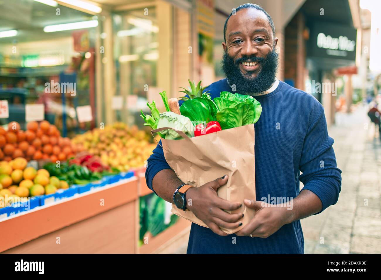 African american man with beard holding paper bag of groceries from ...