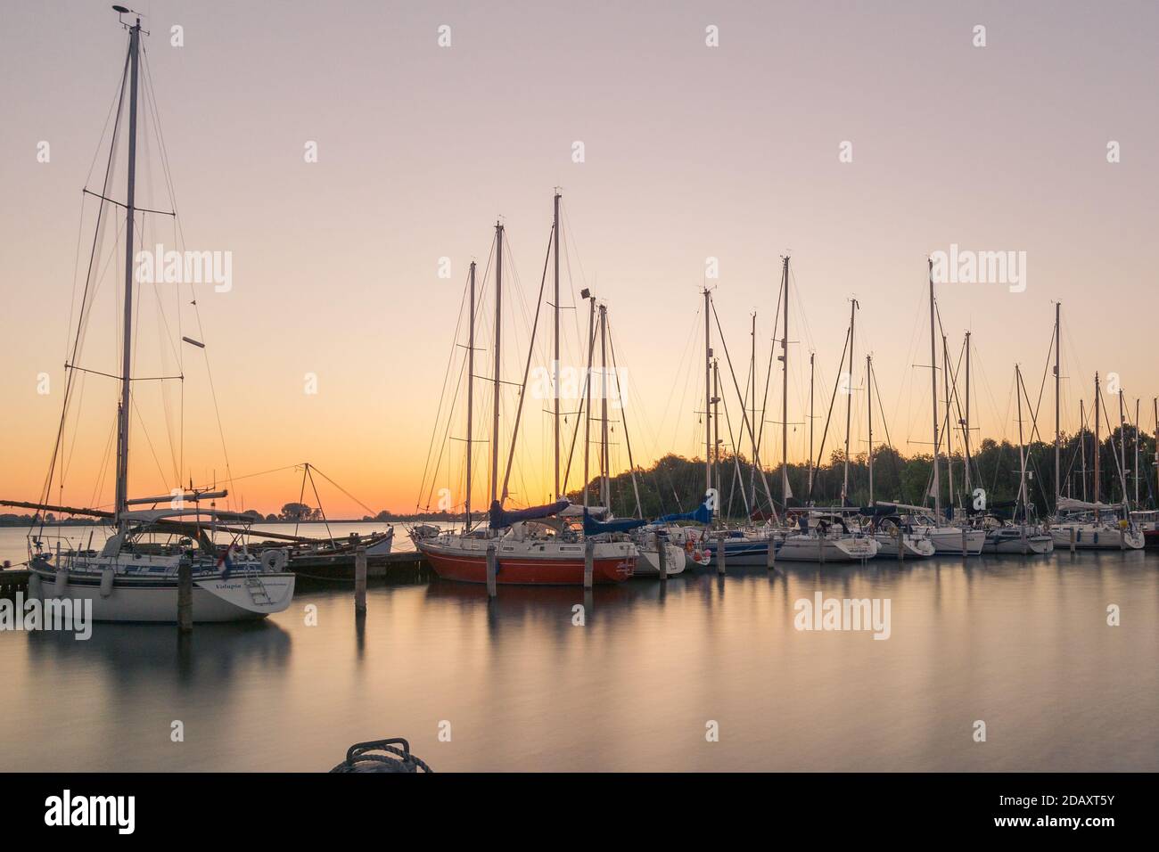 Silent dutch harbour with sailing boats at sunrise Stock Photo - Alamy