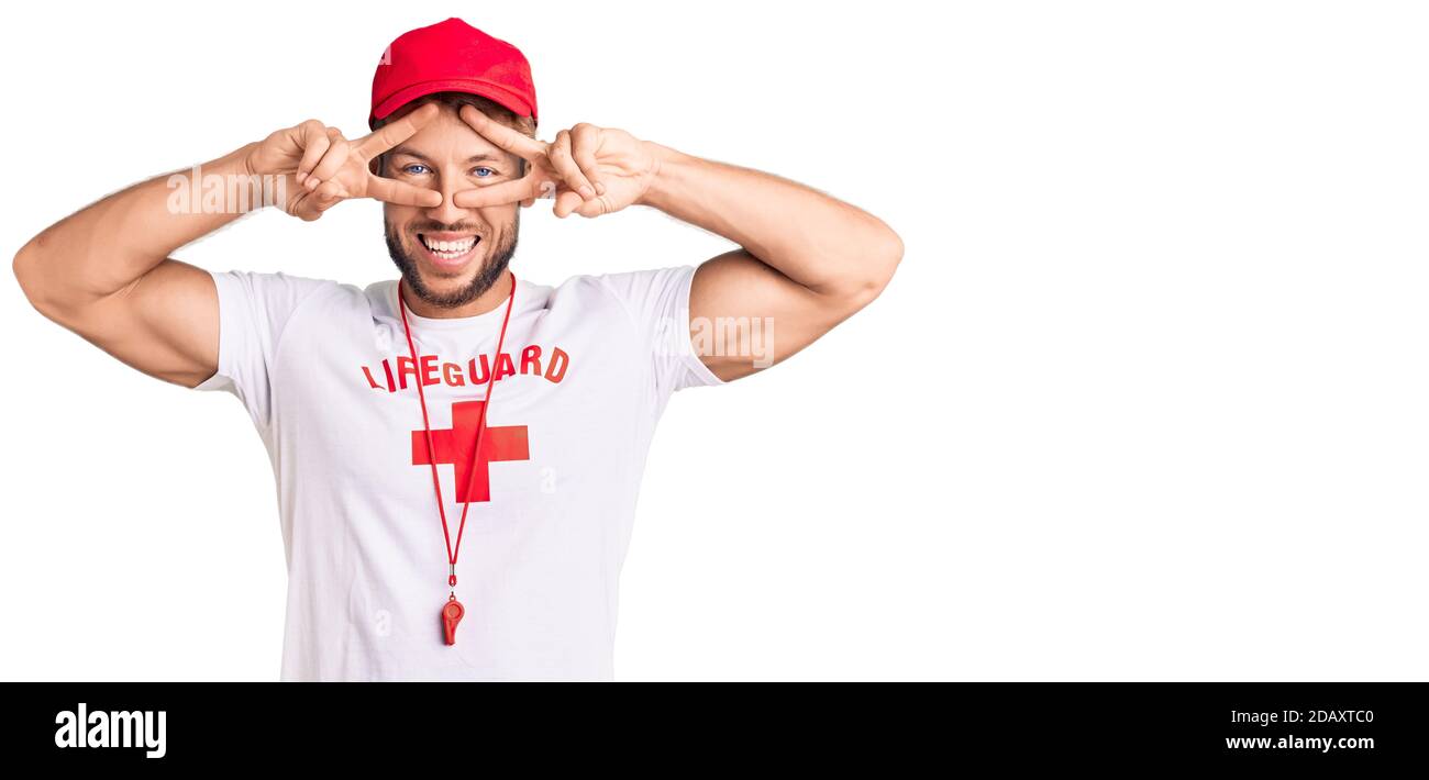 Young caucasian man wearing lifeguard t shirt holding whistle doing ...