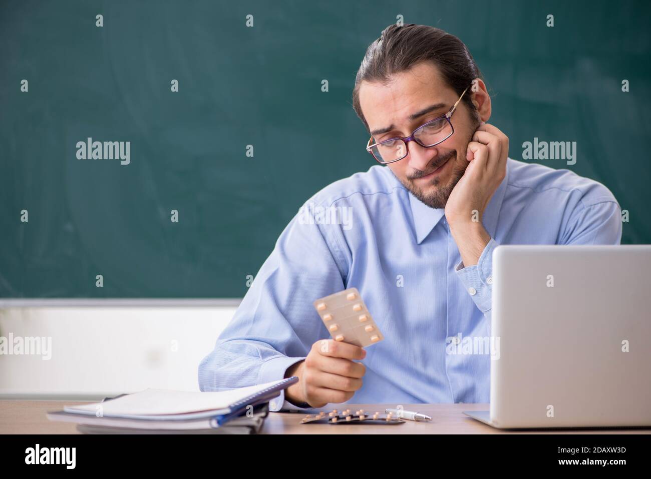 Young sick teacher in the classroom Stock Photo - Alamy
