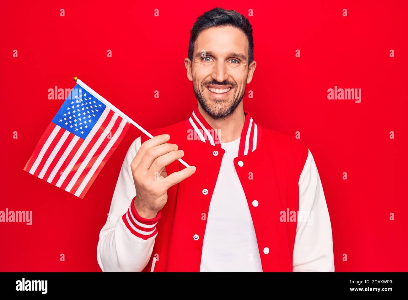 Young handsome patriotic man holding united states flag celebrating ...