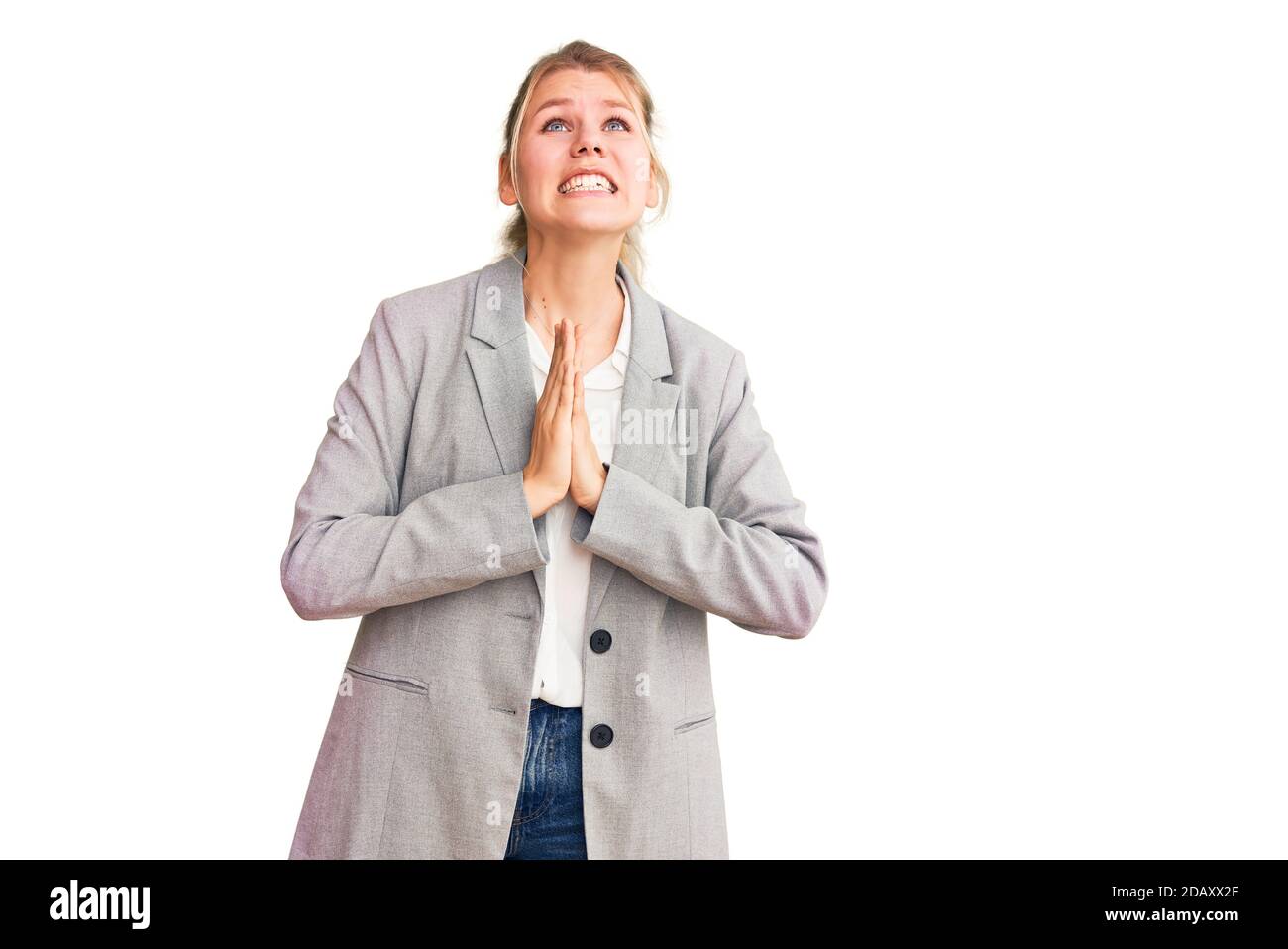 Young beautiful blonde woman wearing elegant jacket begging and praying ...