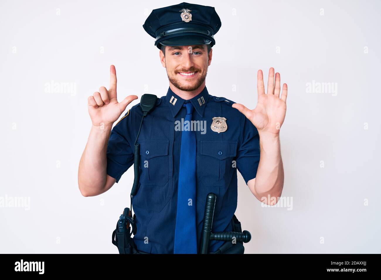 Young caucasian man wearing police uniform showing and pointing up with ...