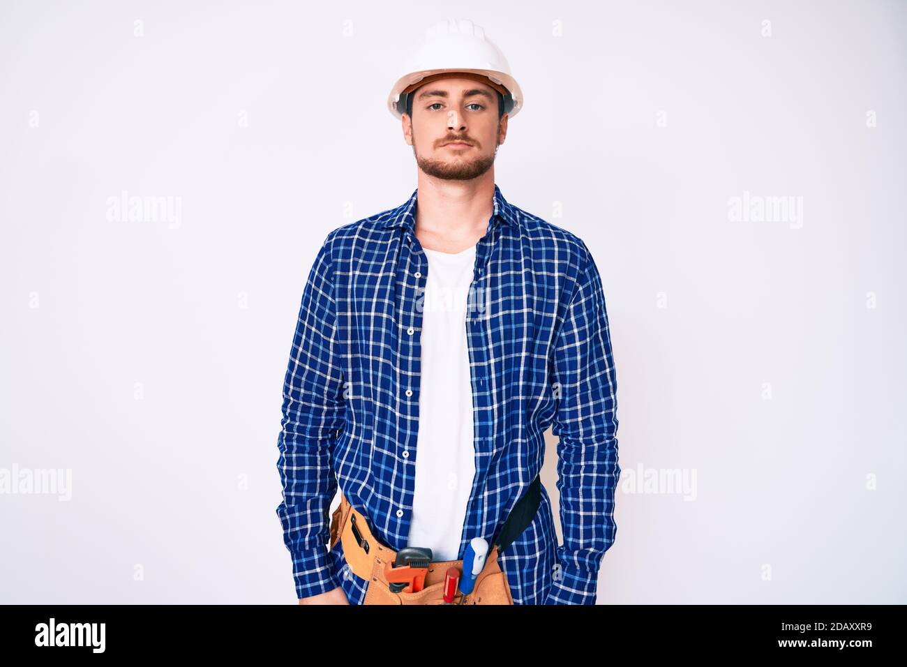 Young handsome man weaing handyman uniform with serious expression on ...