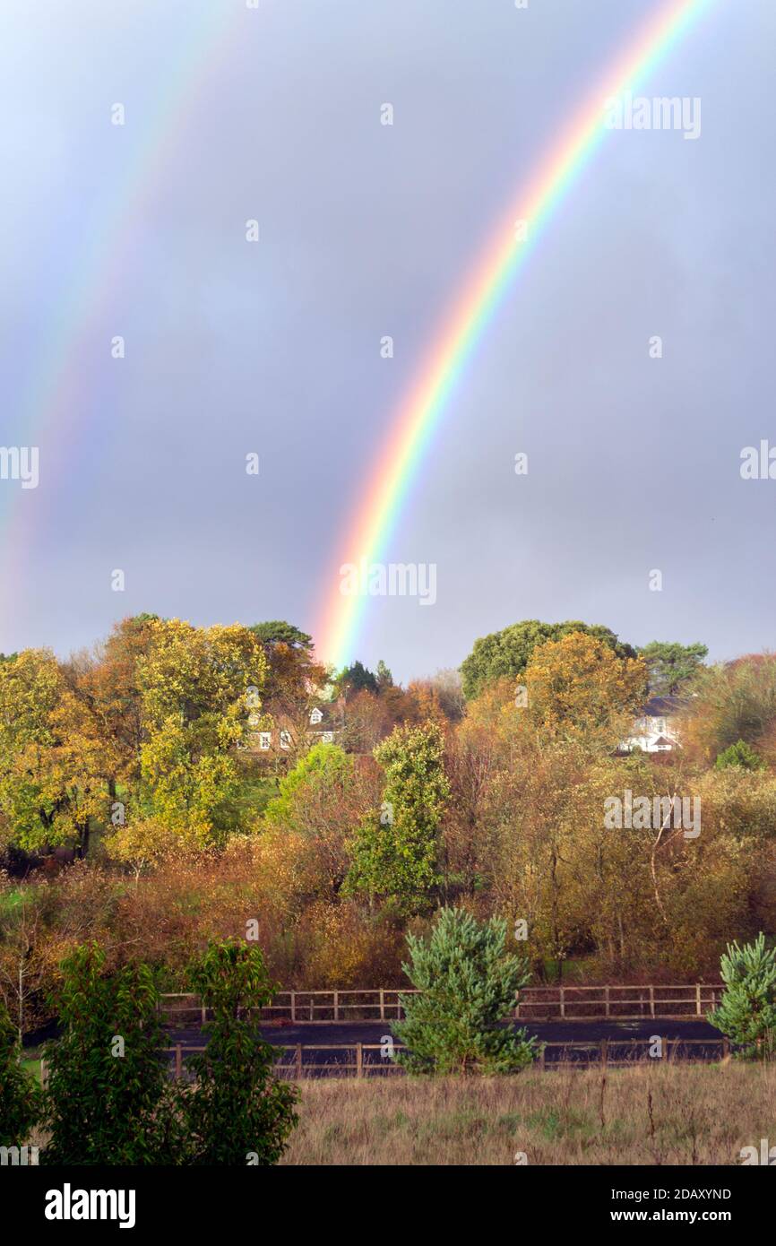 Double rainbows shining over trees with autumn colours Stock Photo - Alamy