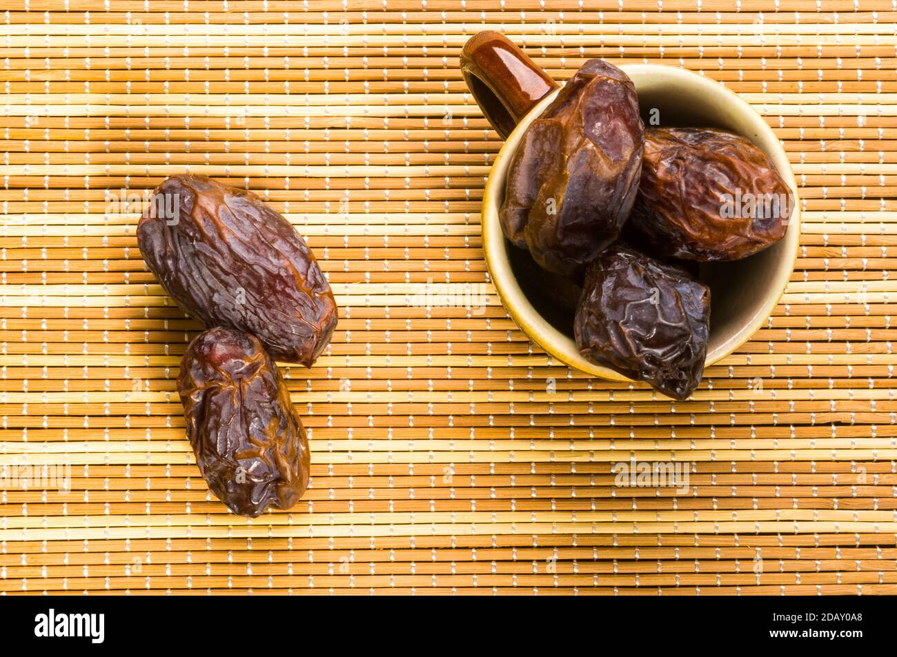 Big luxury dried date fruit in bowls on the bamboo mat, kurma ramadan ...
