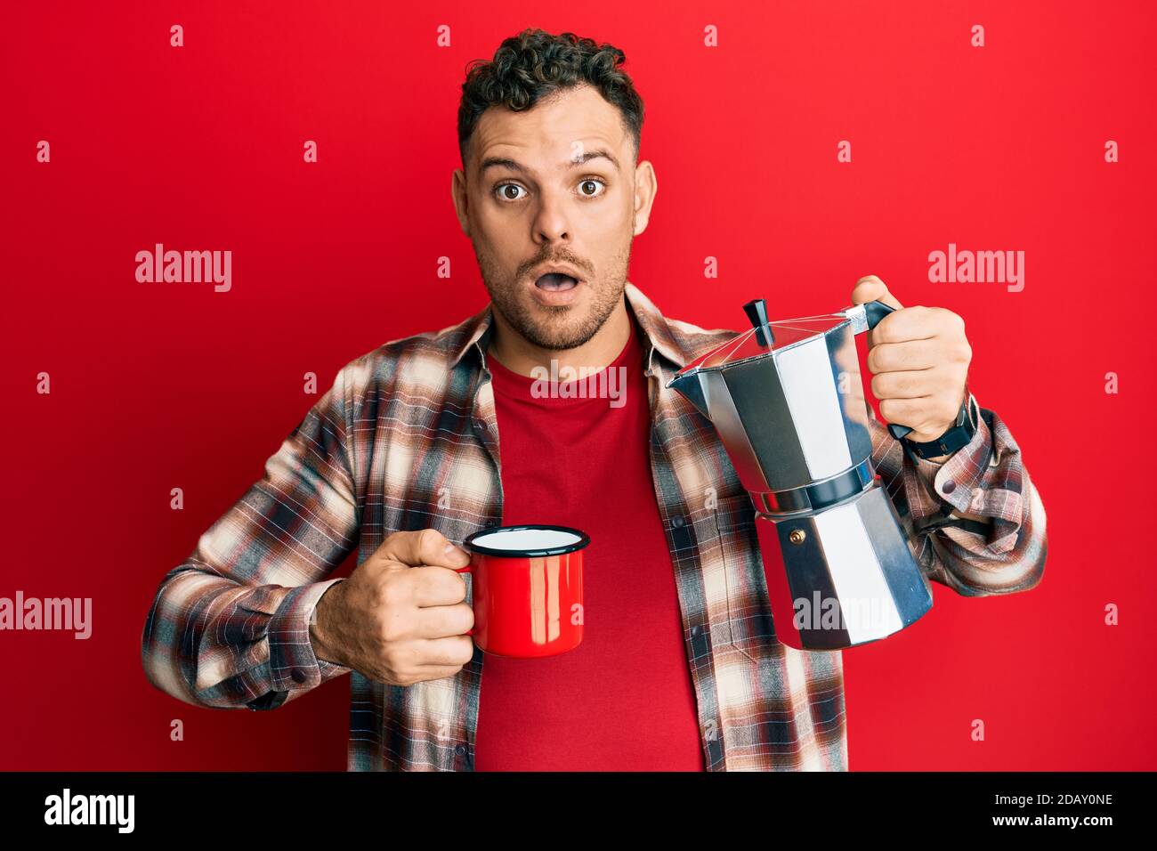Handsome man with beard holding italian coffee maker relaxed with ...