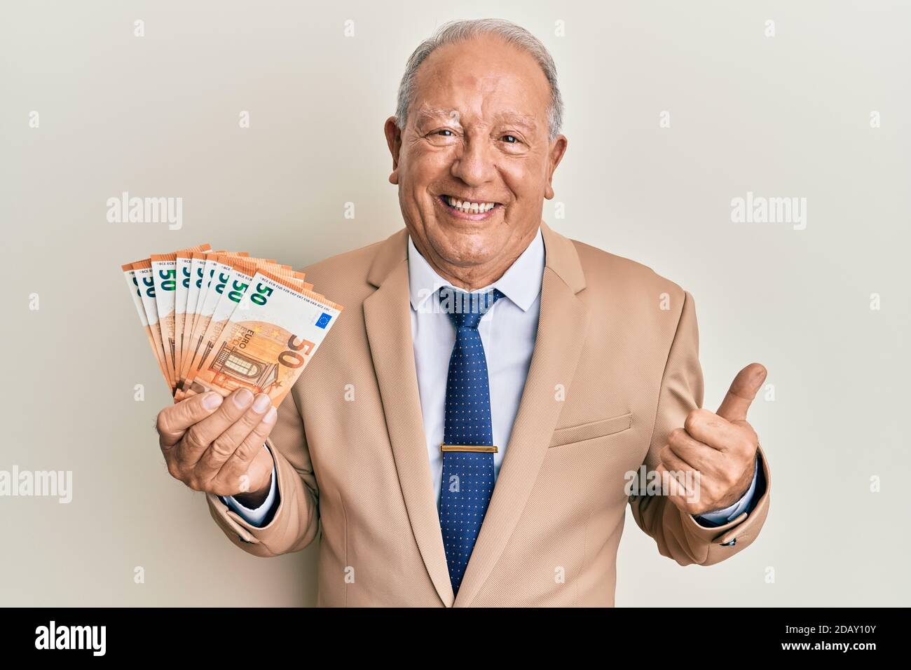 Senior caucasian man holding euro banknotes smiling happy and positive ...