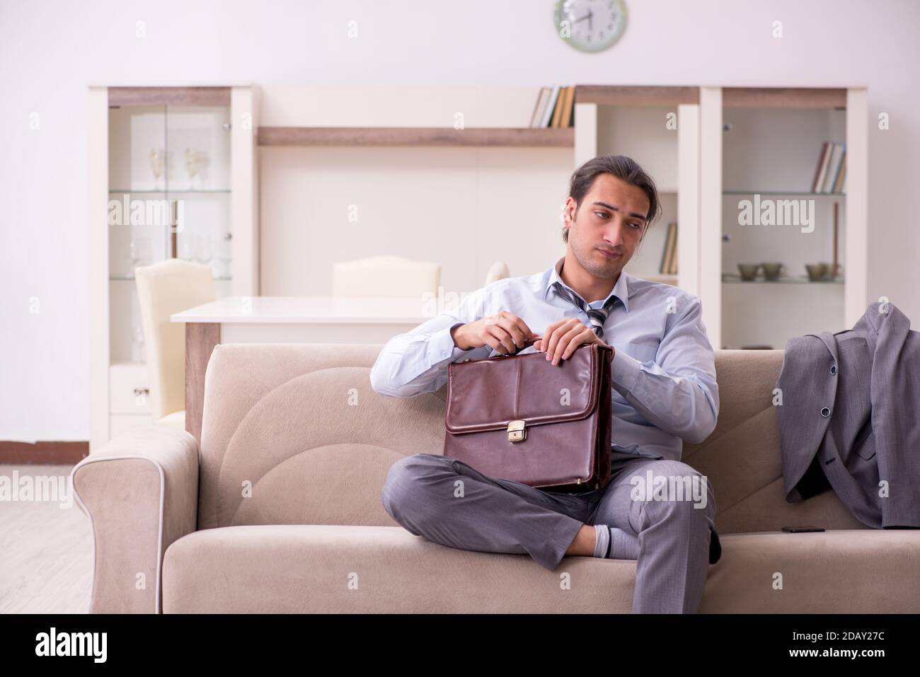 Tired businessman coming home after working day Stock Photo - Alamy