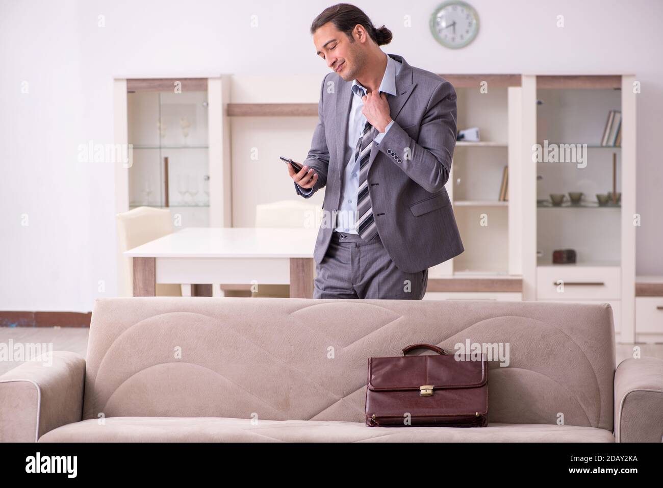 Tired businessman coming home after working day Stock Photo - Alamy