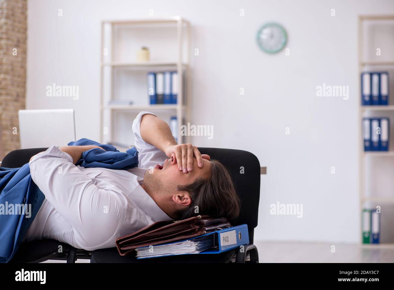 Young employee sleeping in the office on chairs Stock Photo - Alamy