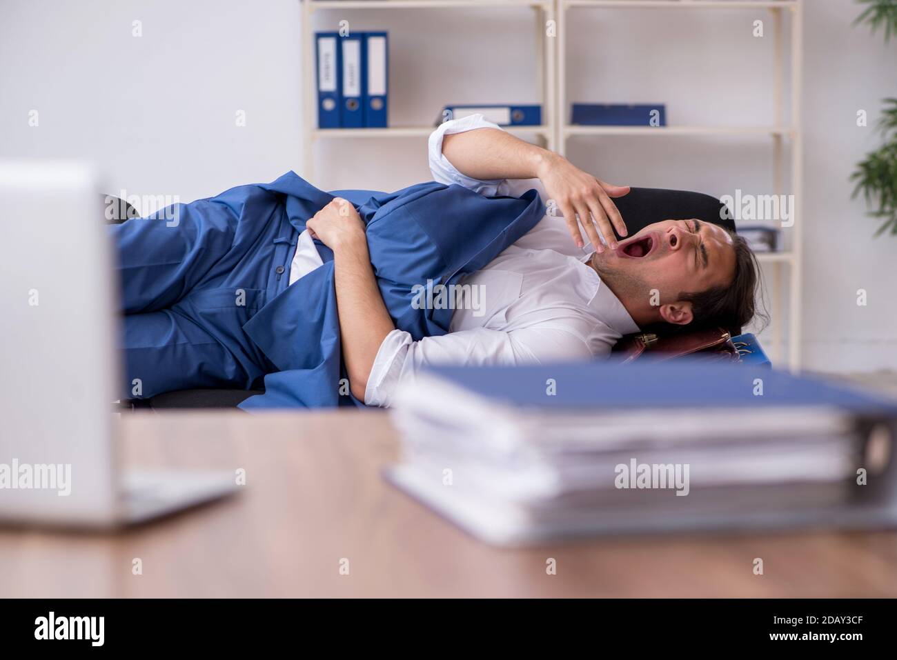 Young employee sleeping in the office on chairs Stock Photo - Alamy