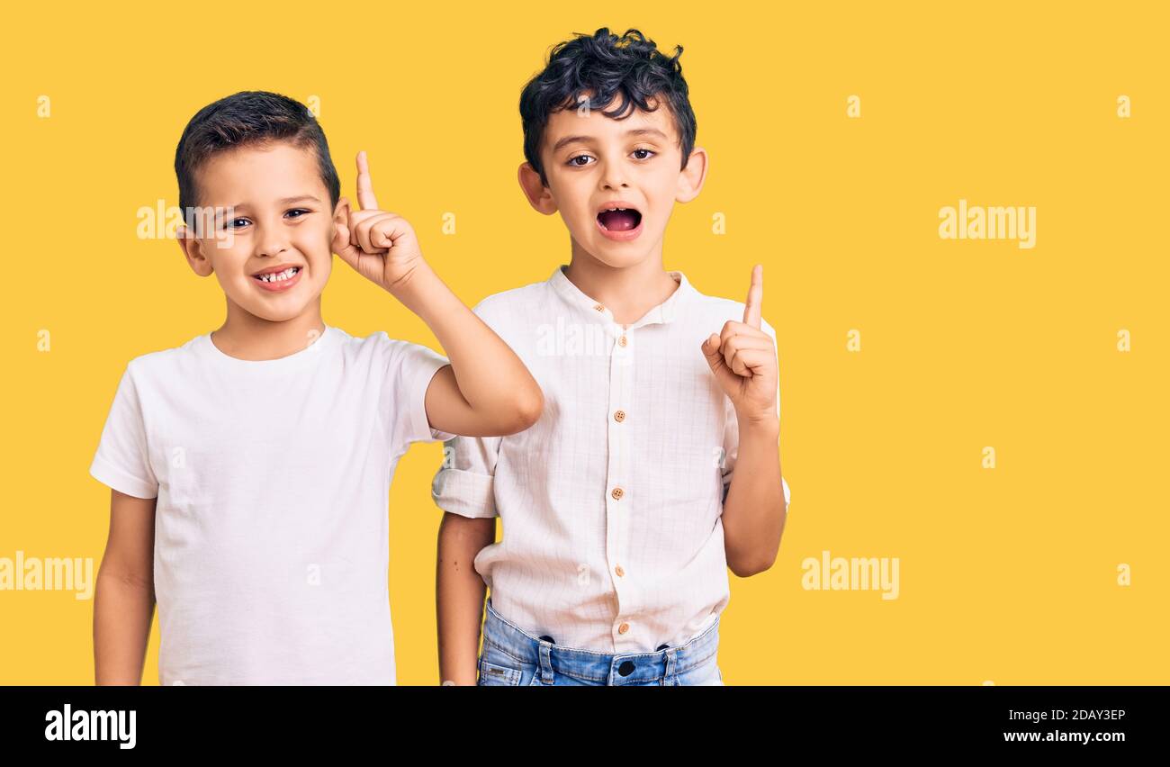 Couple of little brothers together wearing casual clothes pointing ...