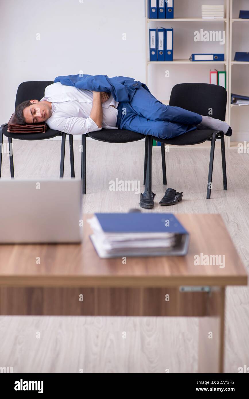 Young employee sleeping in the office on chairs Stock Photo - Alamy