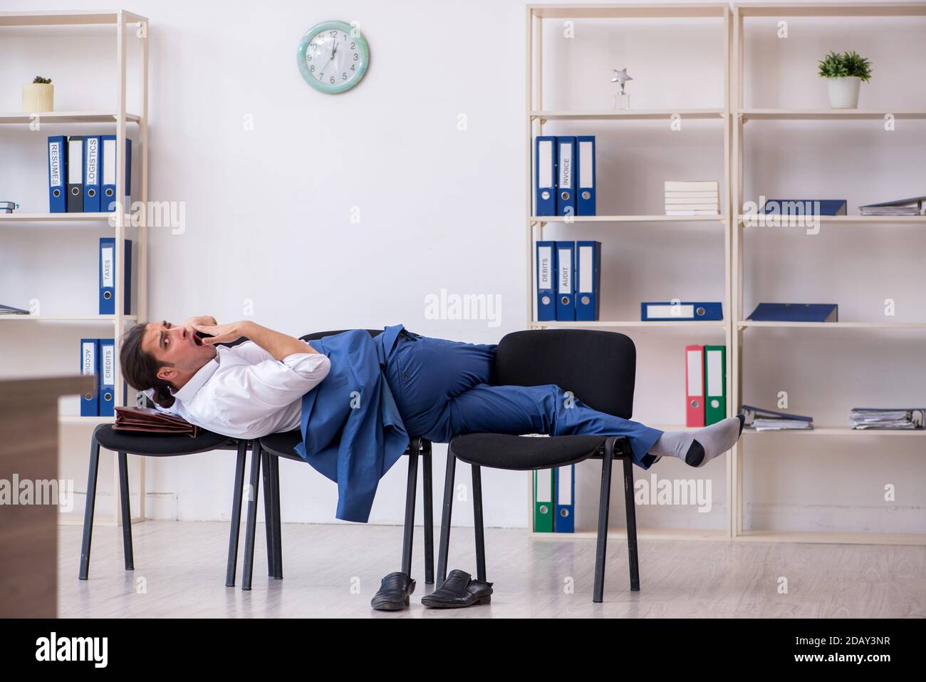Young employee sleeping in the office on chairs Stock Photo - Alamy