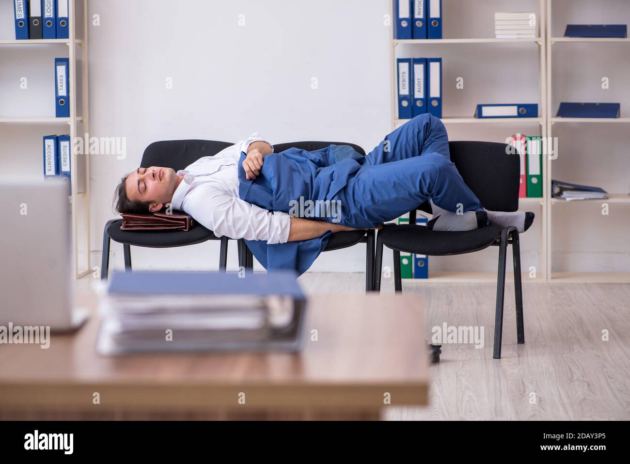 Young employee sleeping in the office on chairs Stock Photo - Alamy