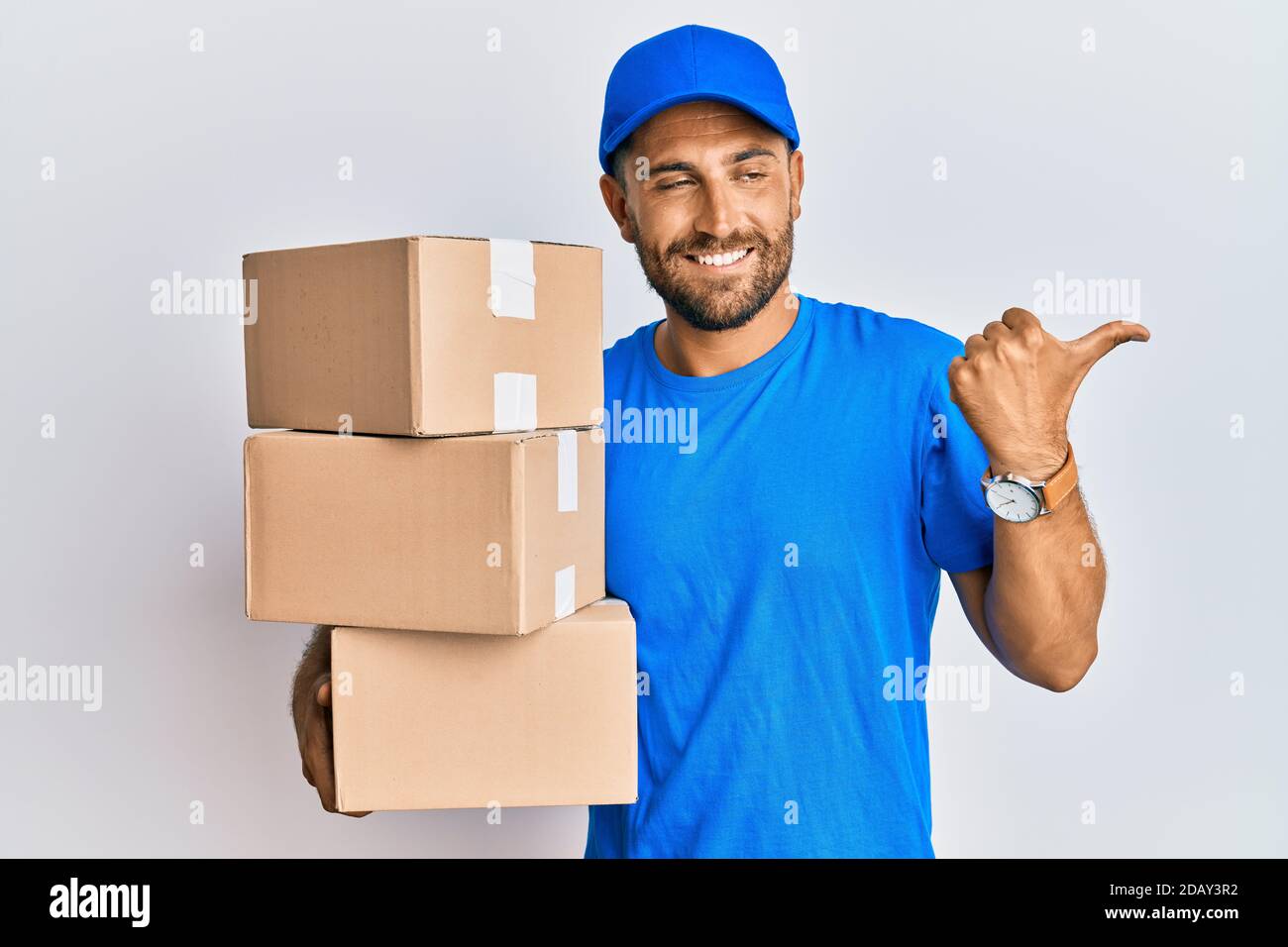 Handsome man with beard wearing courier uniform holding delivery ...