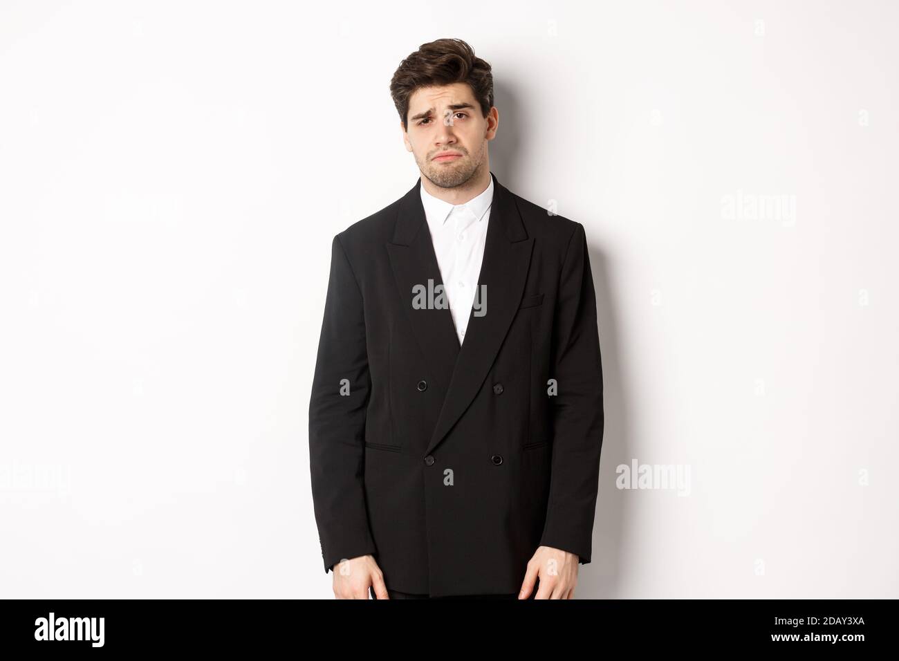 Image of gloomy and sad handsome male model in black suit, frowning and ...