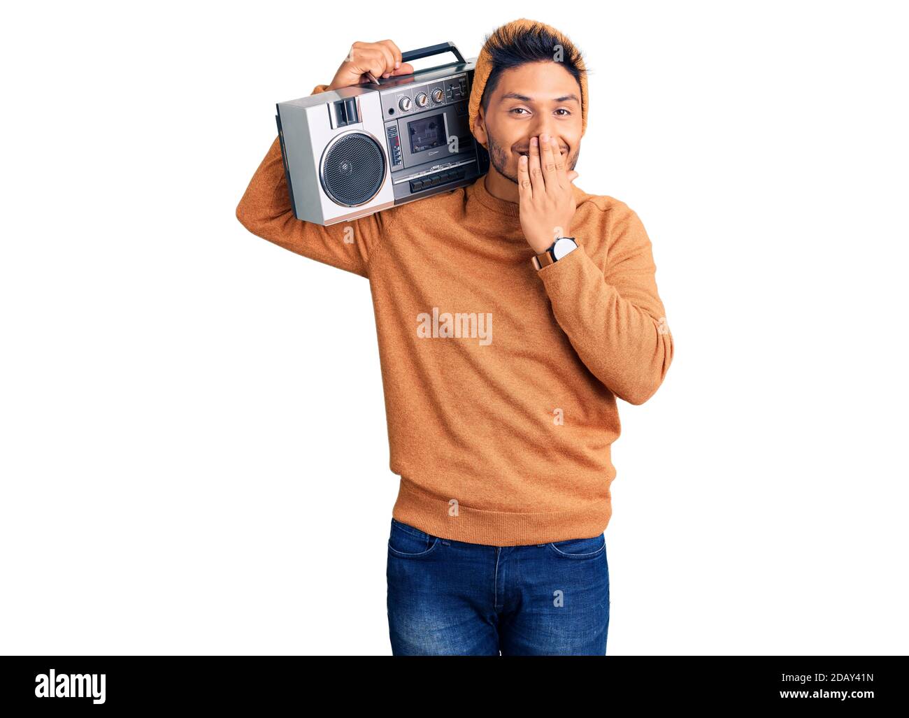Handsome latin american young man holding boombox, listening to music ...