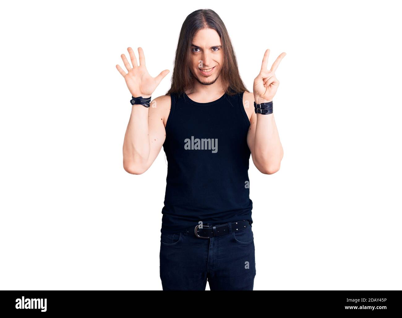 Young adult man with long hair wearing goth style with black clothes ...