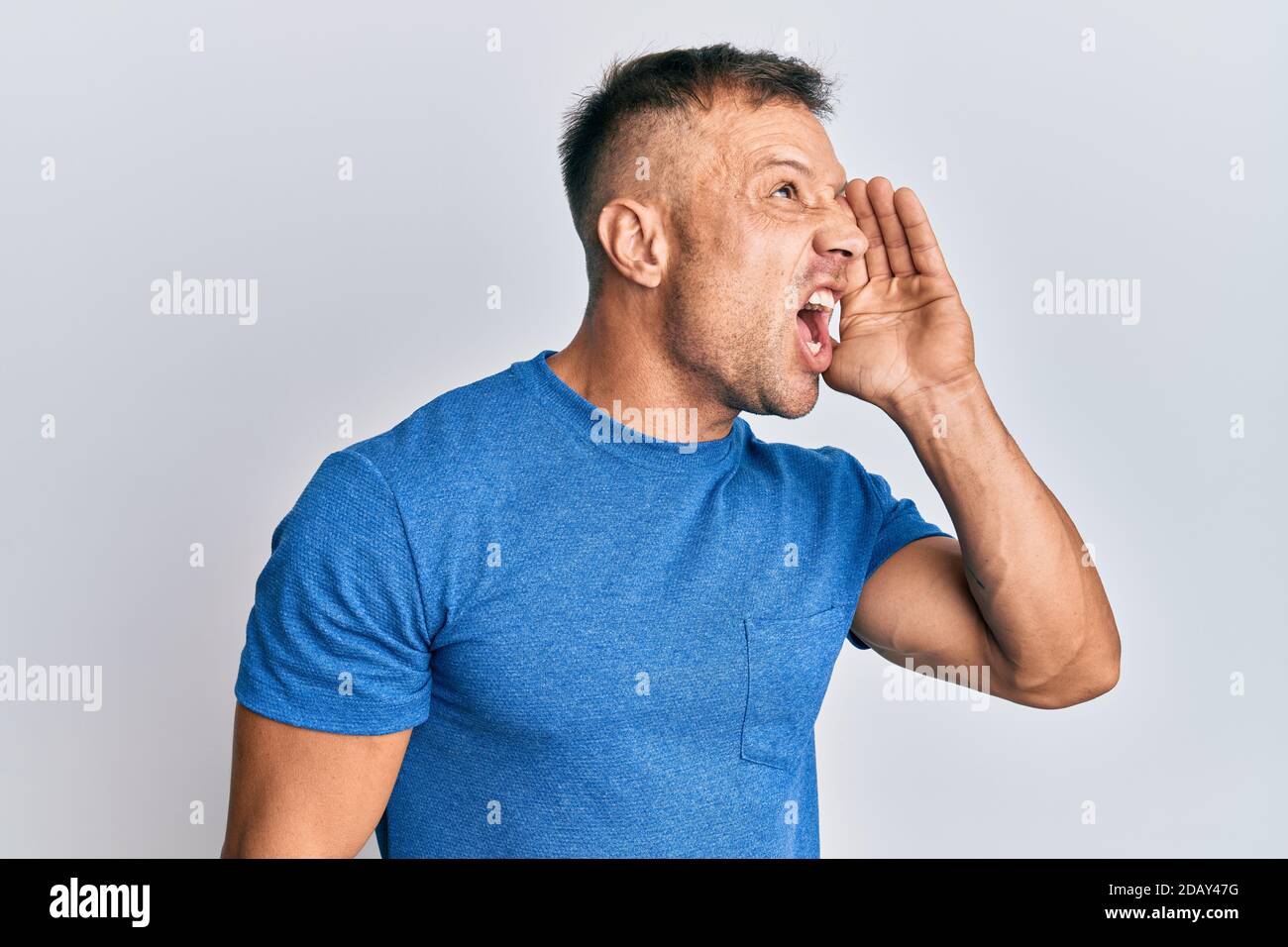 Handsome muscle man wearing casual clothes shouting and screaming loud ...