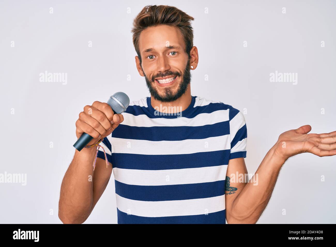 Handsome caucasian man with beard singing song using microphone ...