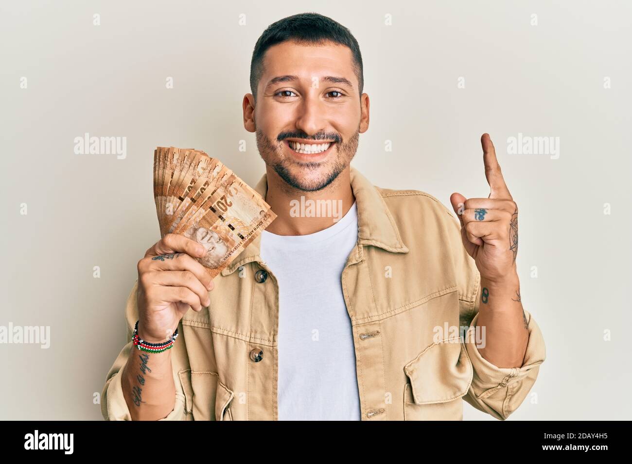Handsome man with tattoos holding south african 20 rand banknotes ...
