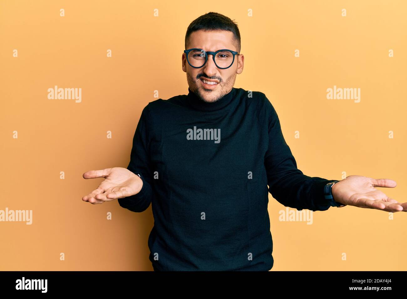 Handsome man with tattoos wearing turtleneck sweater and glasses ...