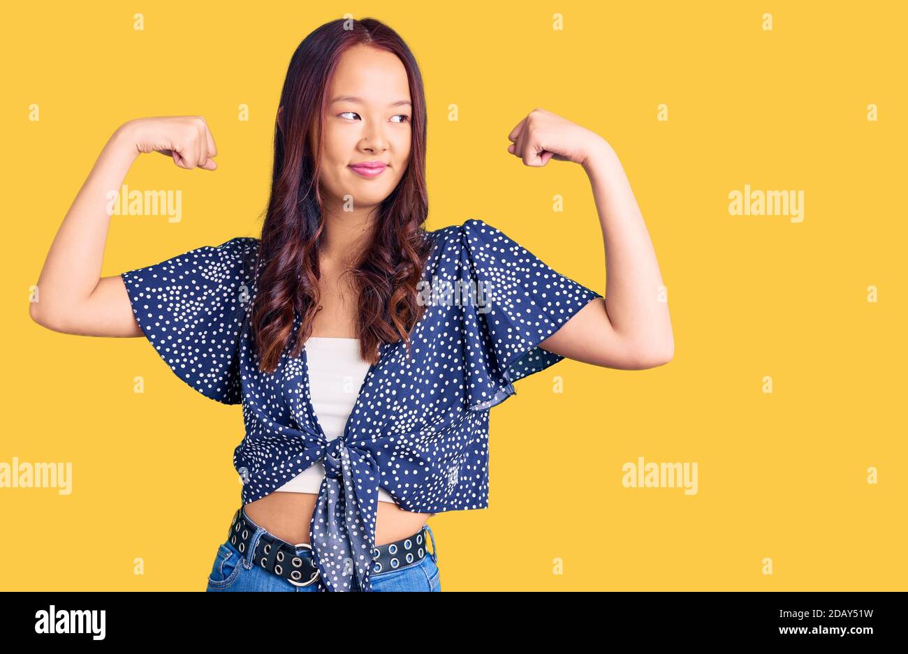 Young beautiful chinese girl wearing casual clothes showing arms ...