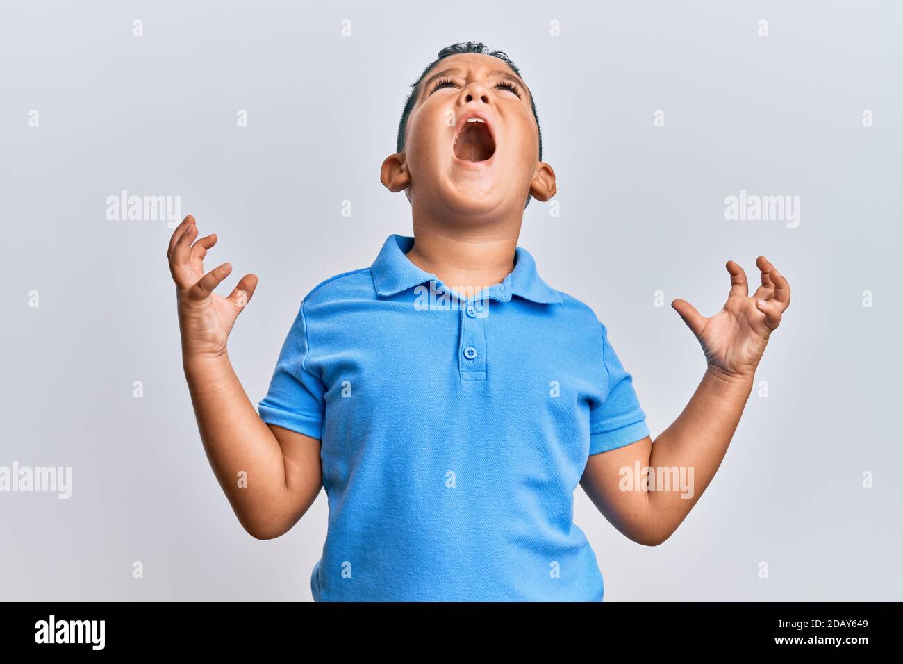 Little boy hispanic kid wearing casual clothes crazy and mad shouting ...