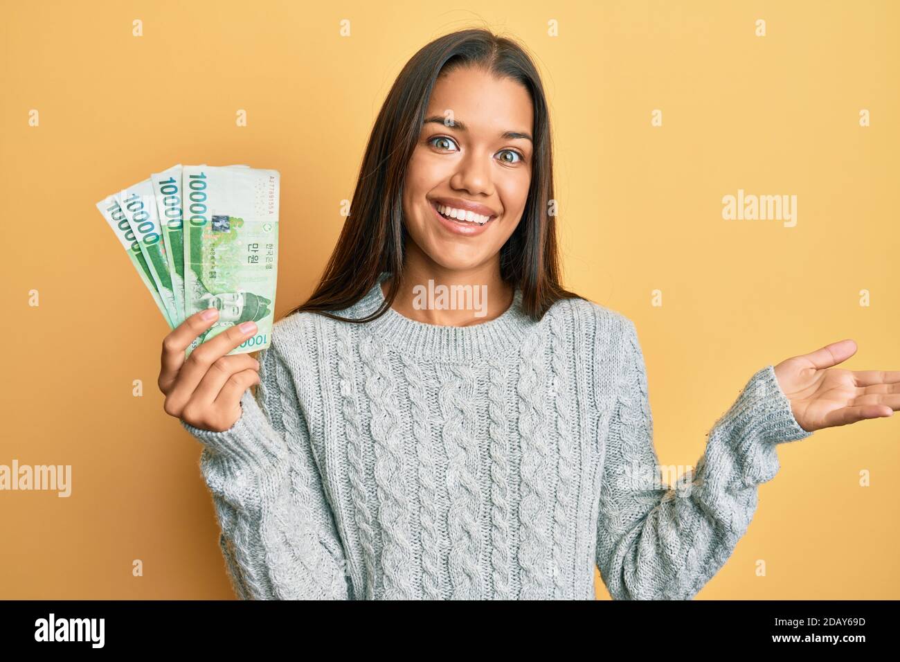 Beautiful hispanic woman holding 10000 south korean won banknotes ...
