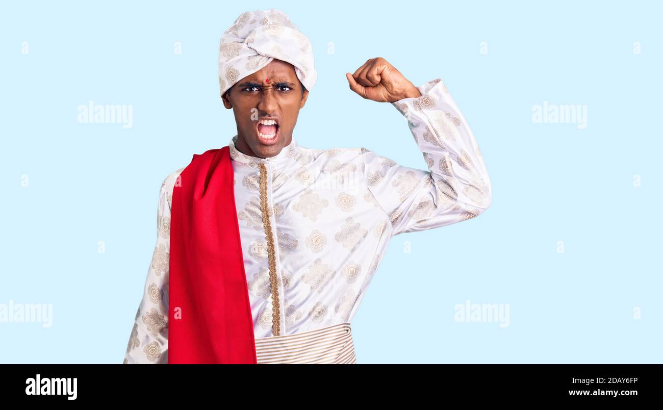 African handsome man wearing tradition sherwani saree clothes angry and ...