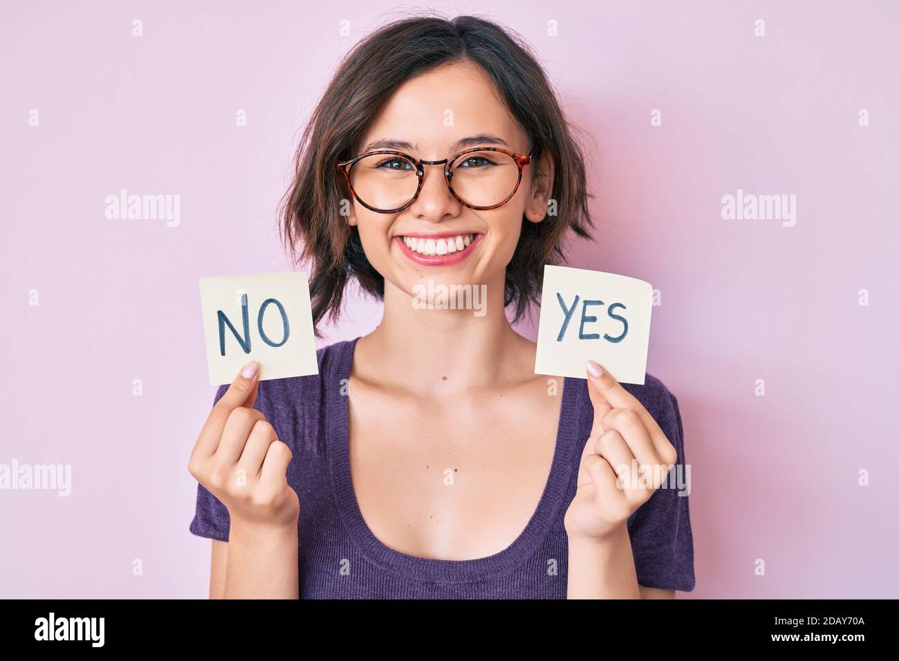 Young beautiful girl holding yes and no reminder smiling with a happy ...